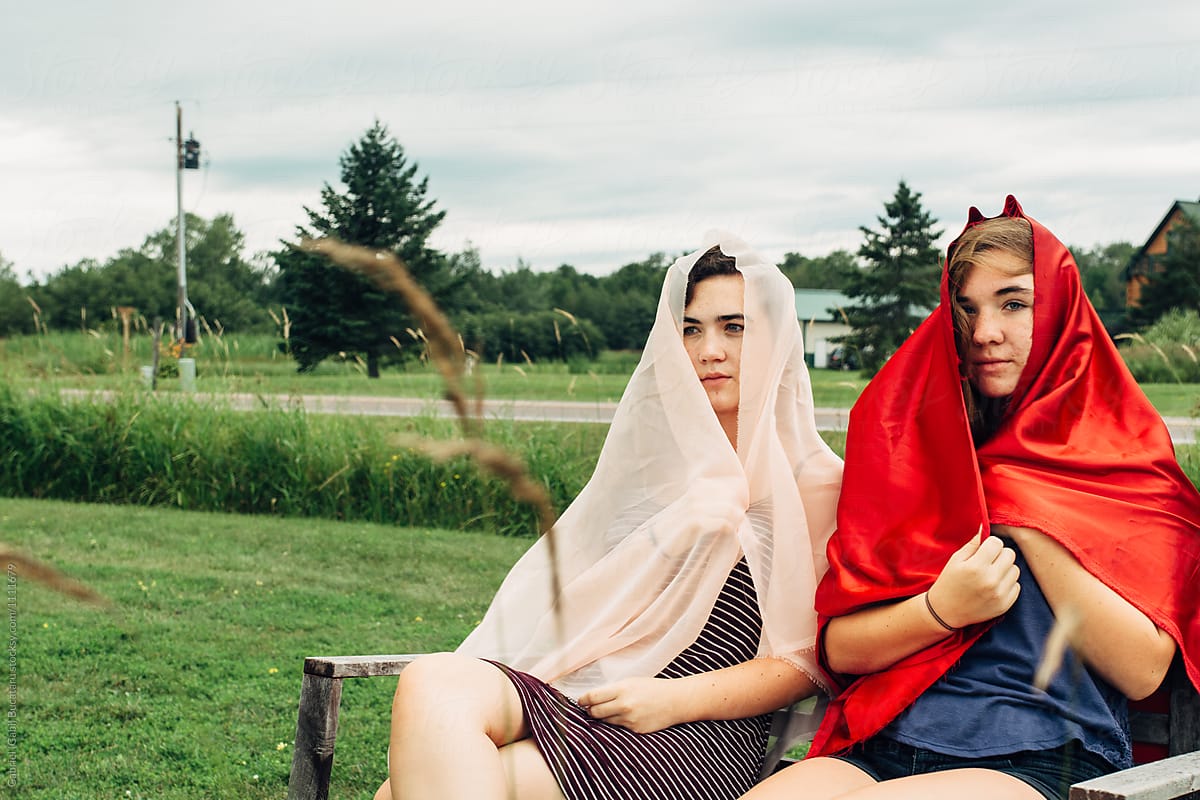 "Two Teenage Girls With Shawls Sitting On A Bench" by Stocksy ...