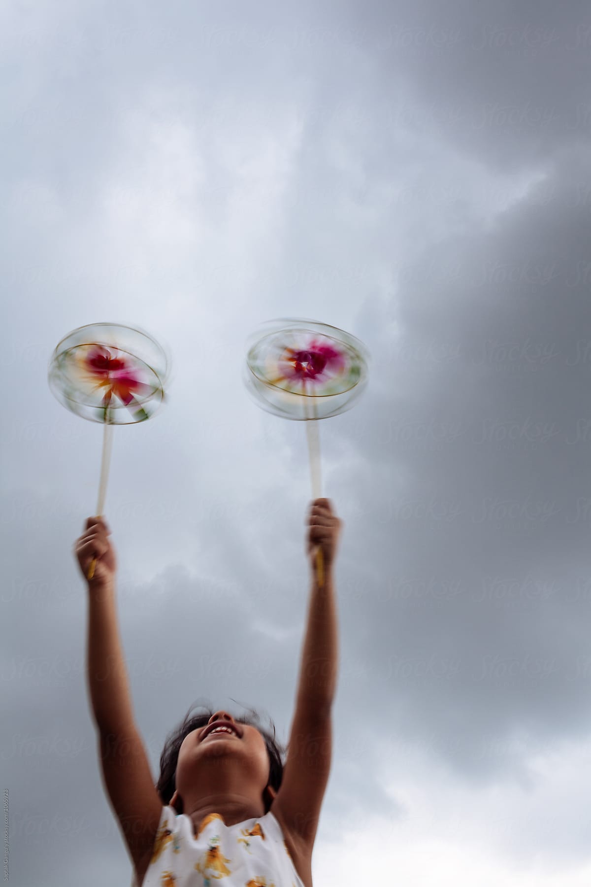 "Child Playing With Pinwheel On A Windy Overcast Day" by Stocksy ...