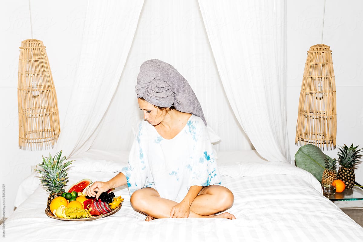 "Young Female Sitting On White Bed Selecting Fruit From Large Tray To ...