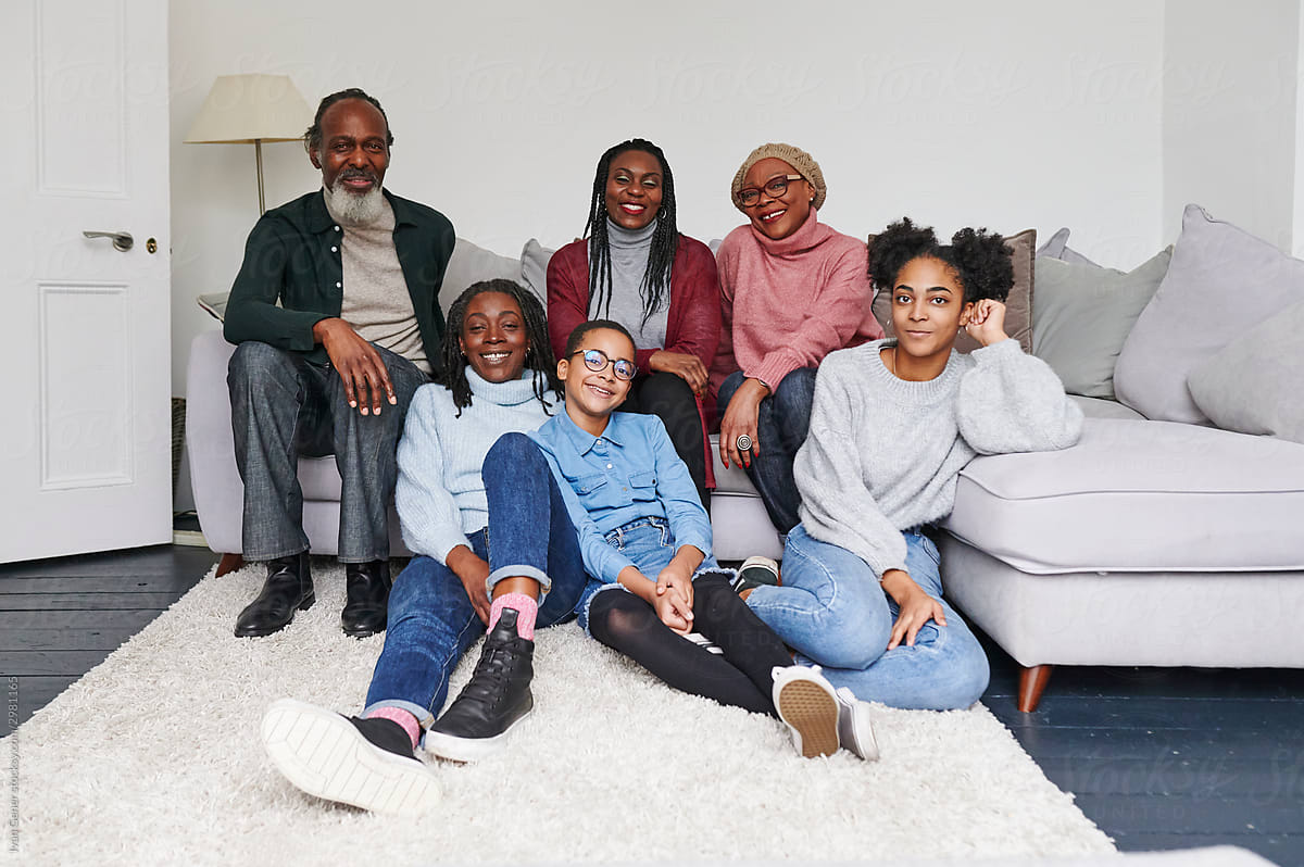 "Smiling Family Sitting Together At Home" by Stocksy Contributor "Ivan ...