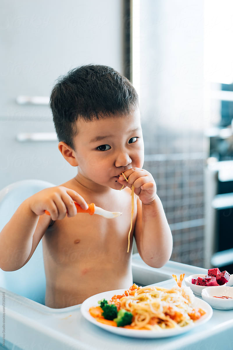 "Adorable Boy Eating At Home" by Stocksy Contributor "MaaHoo" - Stocksy