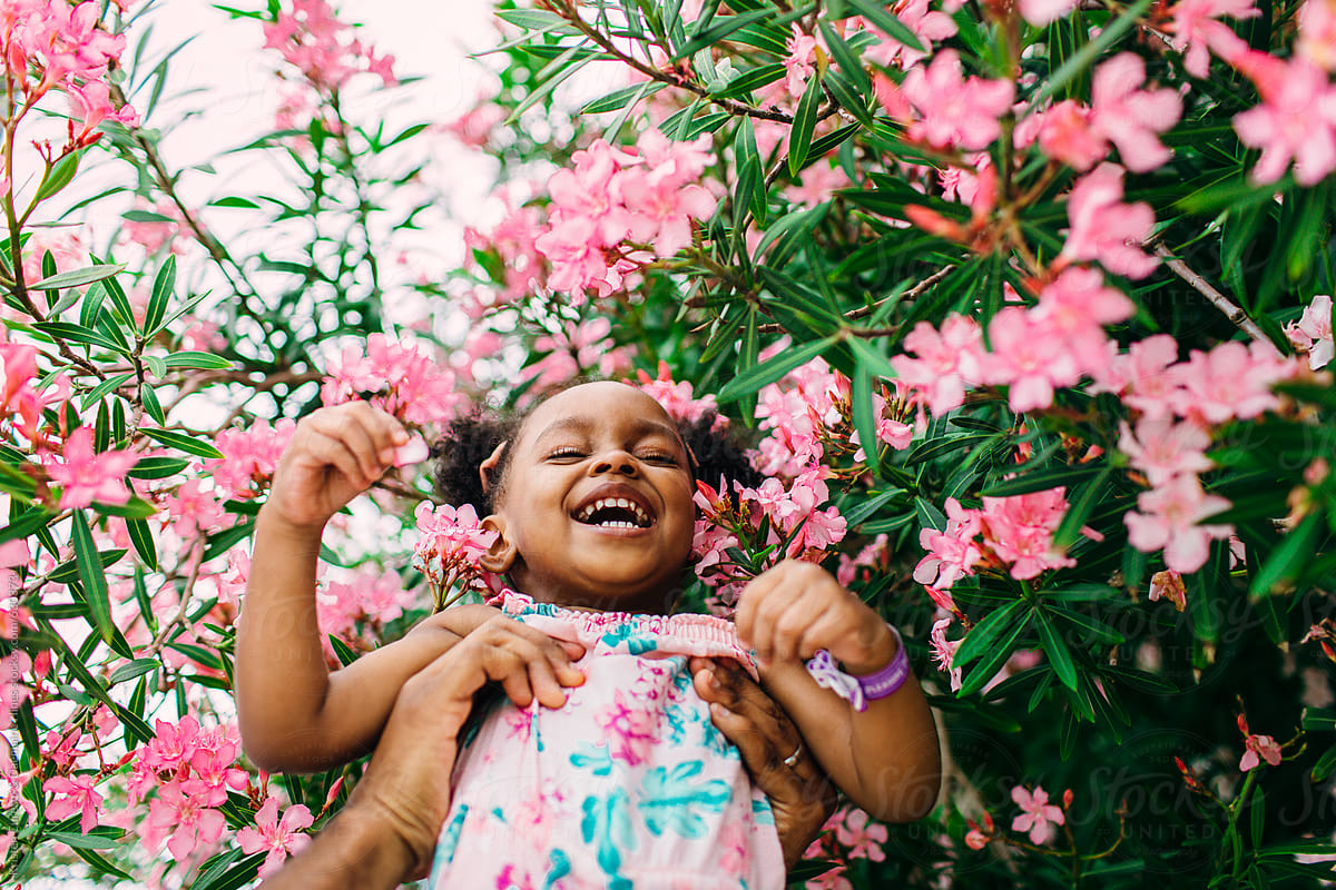 "Adorable Happy Little Girl In Flower Blossoming Garden" by Stocksy ...