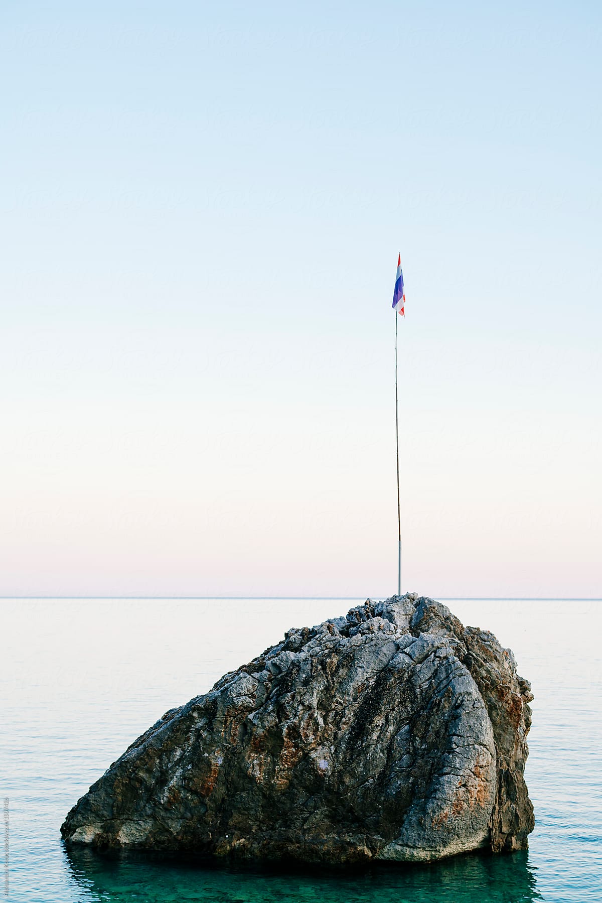 "Little Island Rock With A Flag In The Sea" by Stocksy Contributor ...