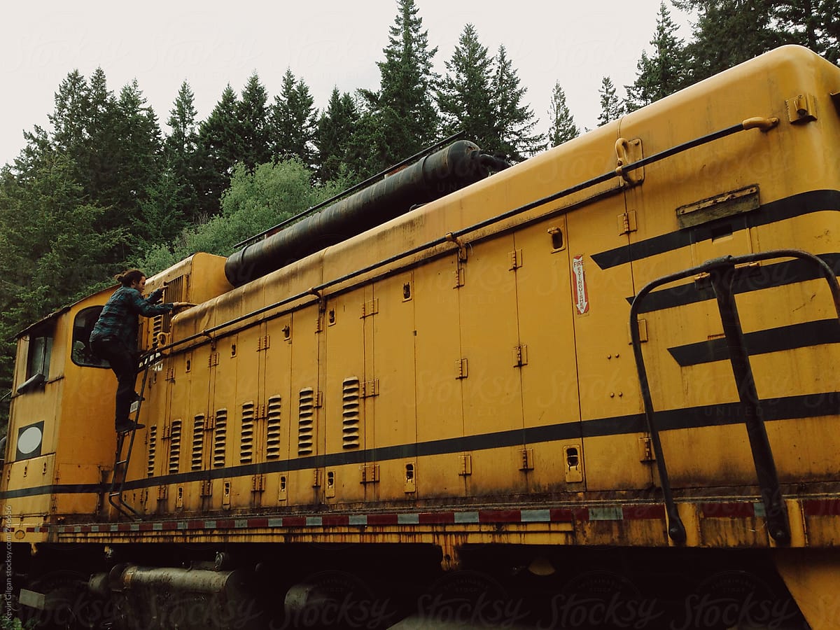 "Man Climbing On Train" by Stocksy Contributor "Kevin Gilgan" - Stocksy