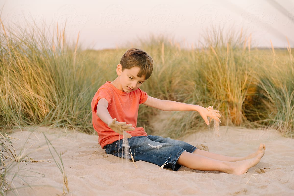 "Child Having Fun Playing With Sand At The Beach" by Stocksy ...