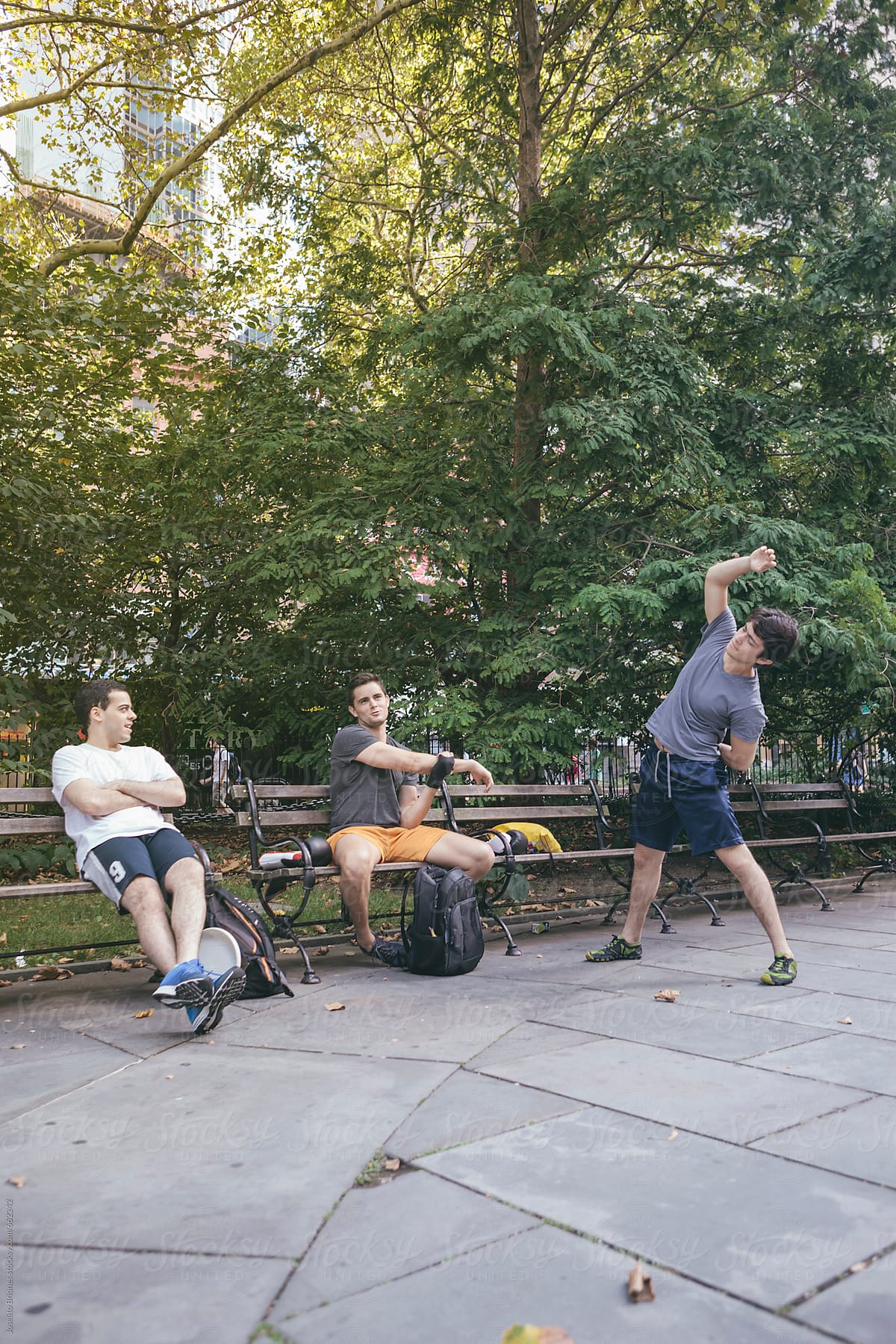 "Young Men Friends Hanging Out In New York Park Stretching Before ...