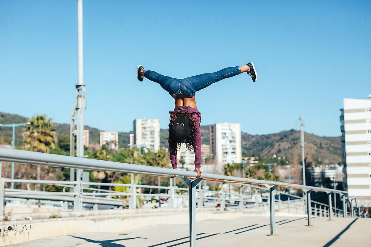 "African American Hip-hop Style Woman Doing A Handstand On A Fence In A ...