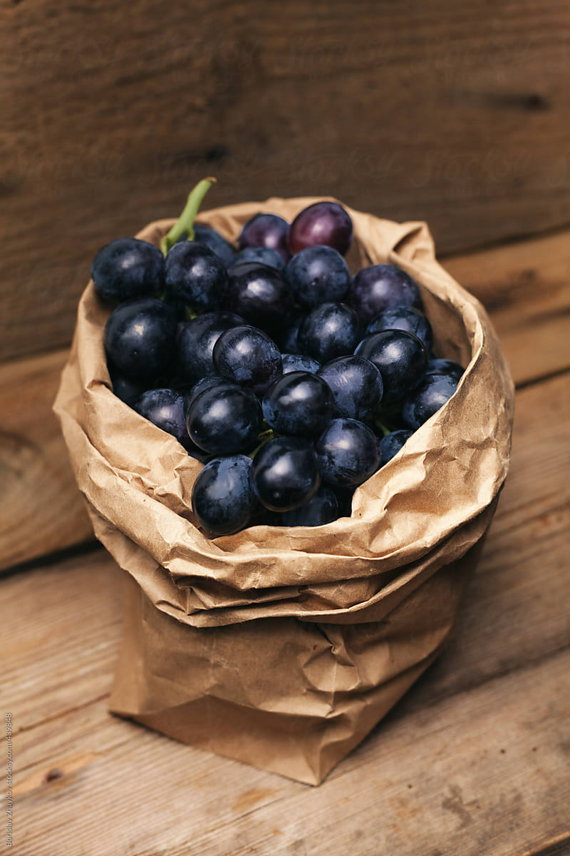 "A Paper Bag Of Grapes" by Stocksy Contributor "Borislav Zhuykov" - Stocksy