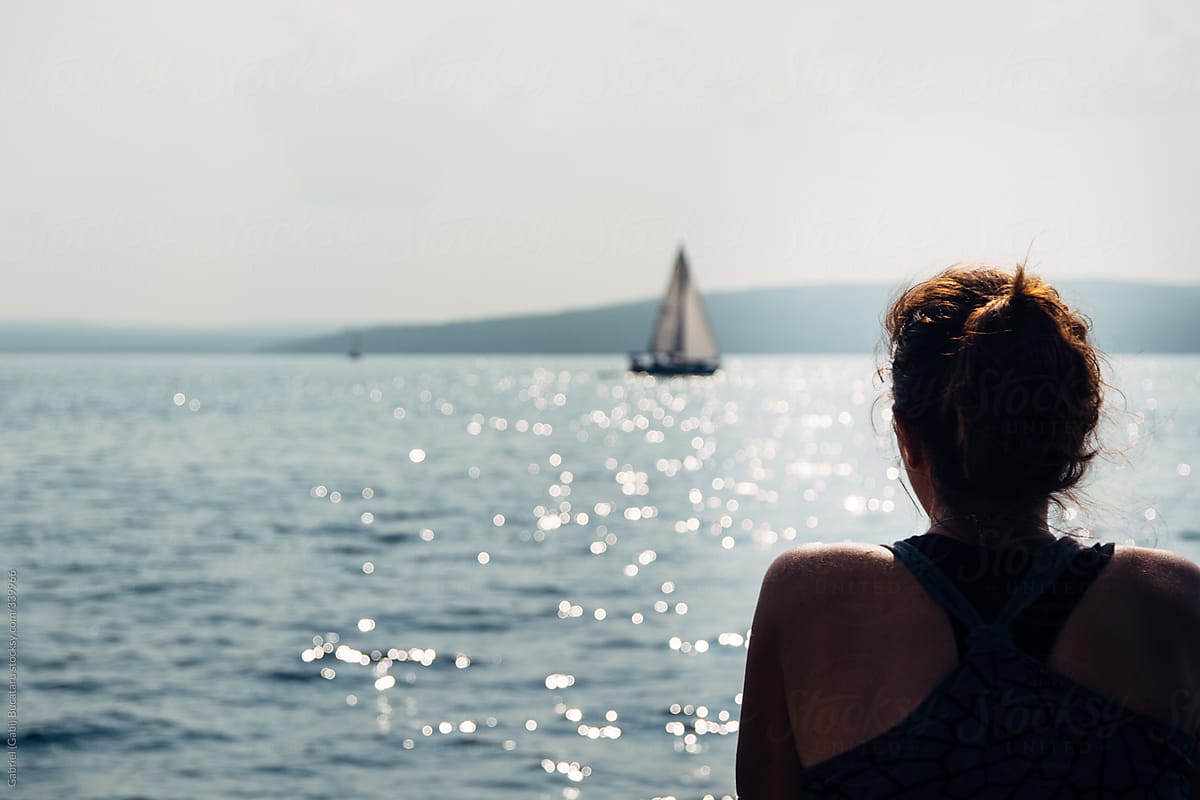 "Woman Looking At A Sail Boat On A Lake" by Stocksy Contributor "Gabi ...