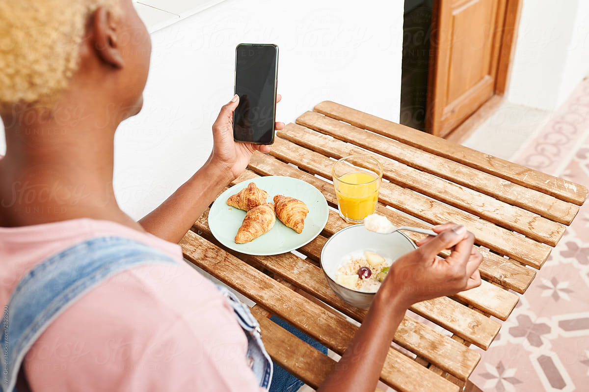"Women Using Her Cellphone Over Breakfast" by Stocksy Contributor "Ivan ...