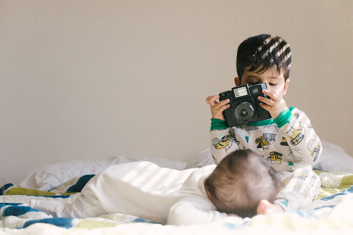 "Toddler Taking Picture Of Baby Sister With Toy Camera" by Stocksy ...