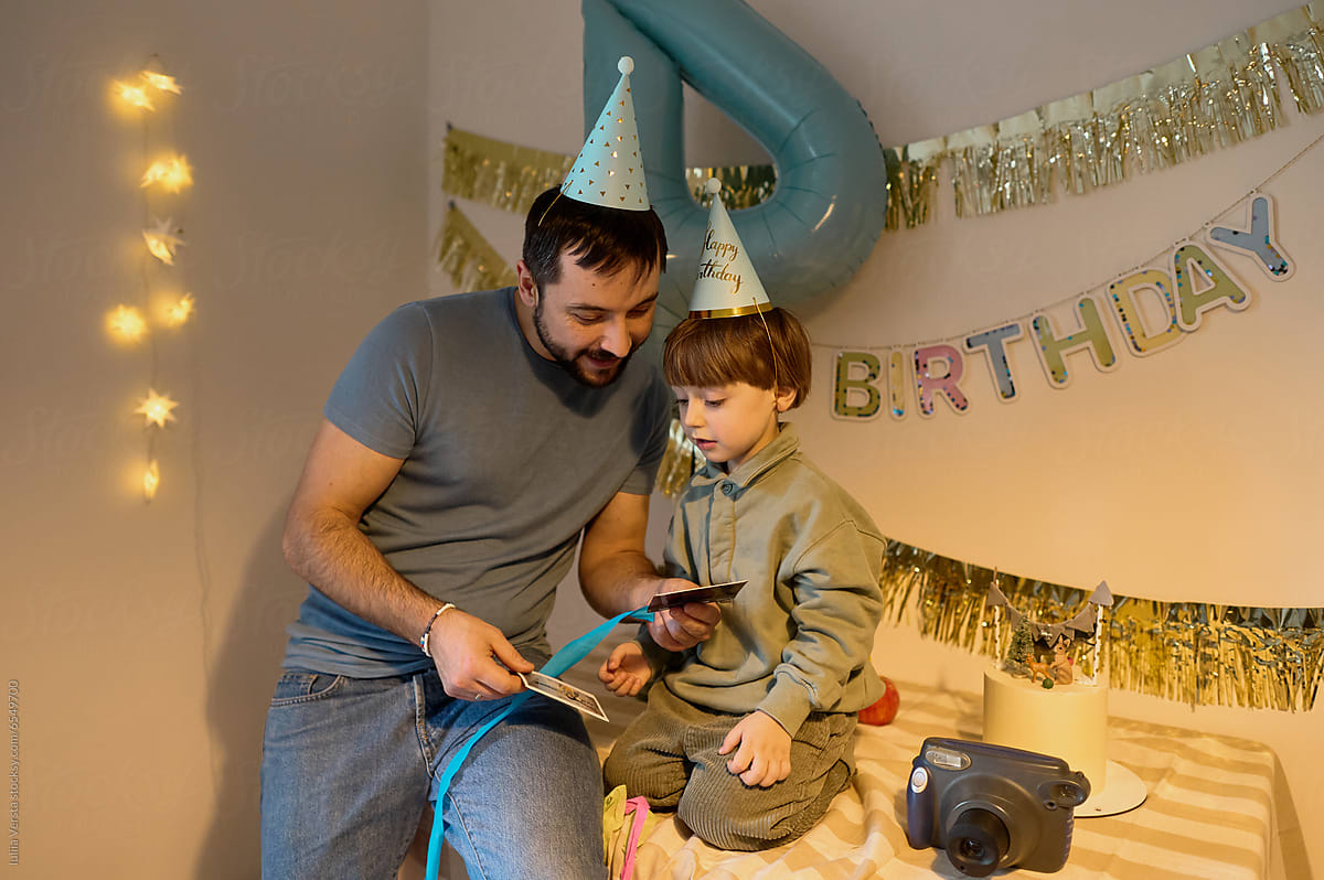 "Dad With Little Son Sitting At A Festive Table Looking At Photo" by ...