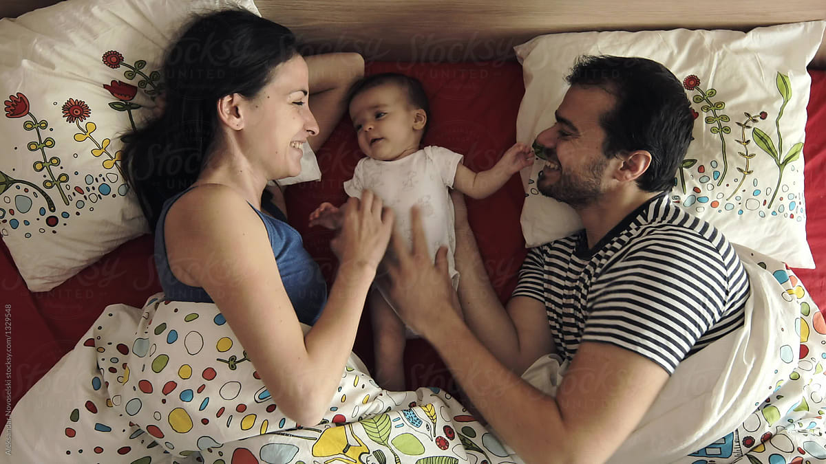 "Young Family Cuddling In Bed" by Stocksy Contributor "Aleksandar ...