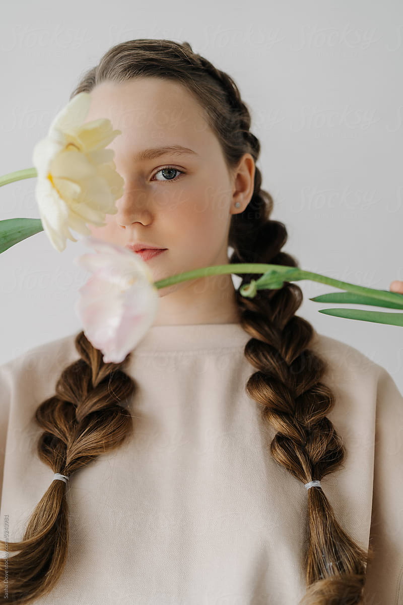 "Young Girl Holds Flowers" by Stocksy Contributor "Sasha Dove" - Stocksy