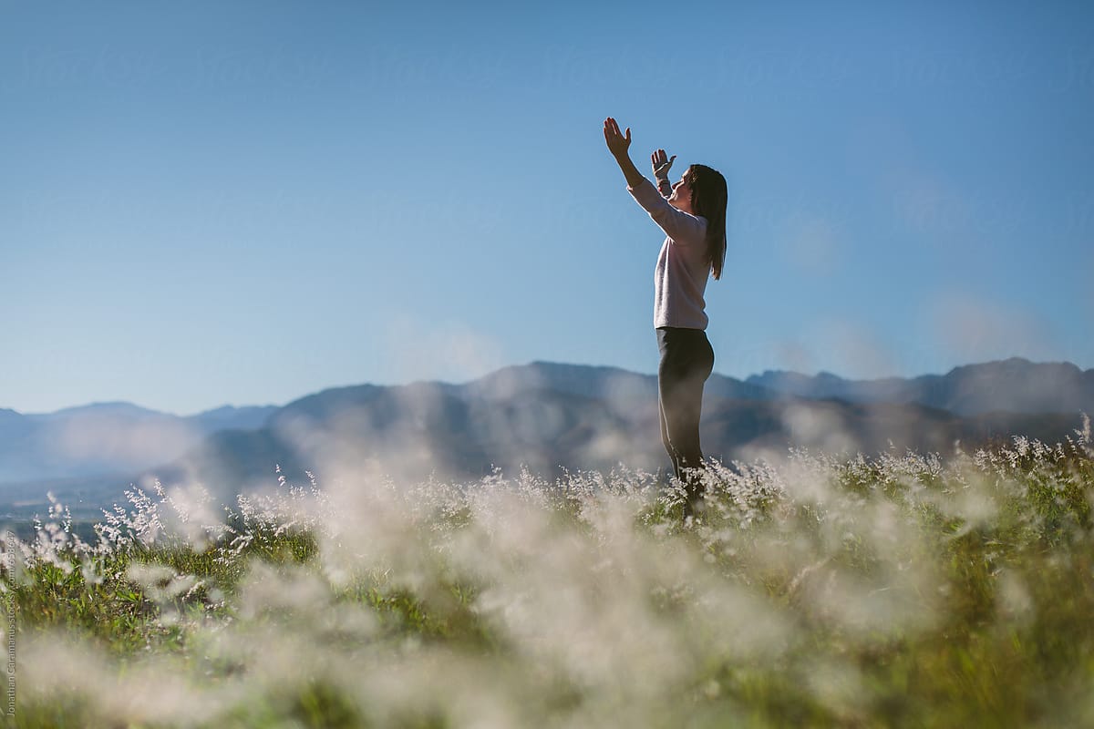 "Beautiful Woman Standing In Grass Field With Arms Reaching For The Sky ...