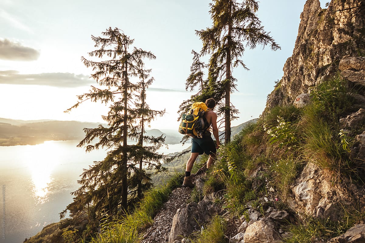 "Male Hiker Hiking Up A Mountain At A Lakeside At Sunset" by Stocksy ...