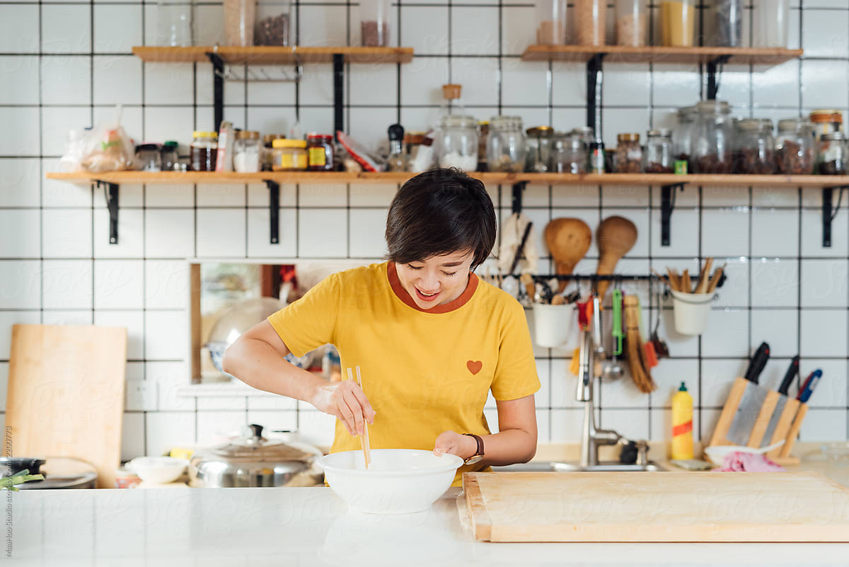 "Young Woman Cooking Indoors" by Stocksy Contributor "MaaHoo" - Stocksy