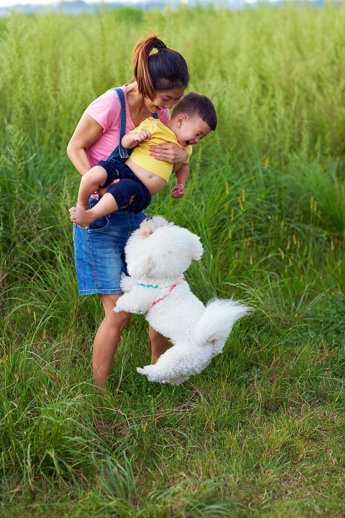 "Happy Family Outdoor With Dog" by Stocksy Contributor "Bo Bo" - Stocksy