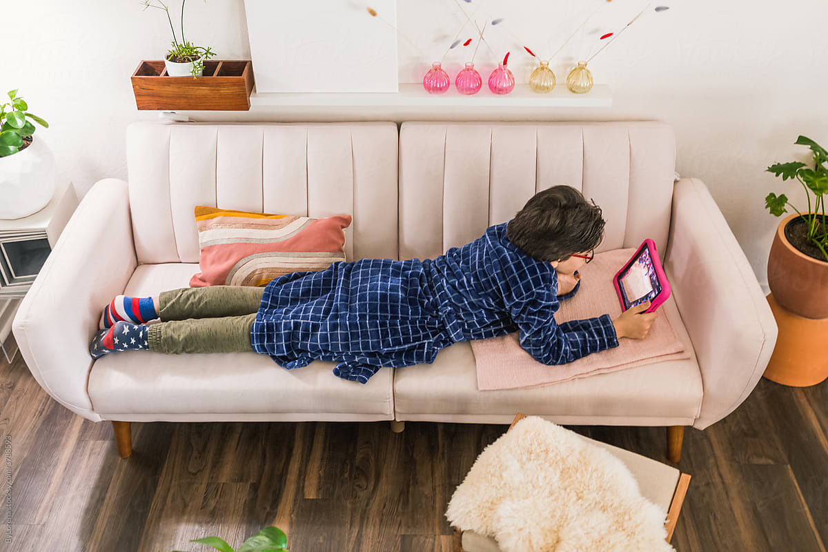 "Boy With Robe Using IPad On Couch" by Stocksy Contributor "ByLorena ...