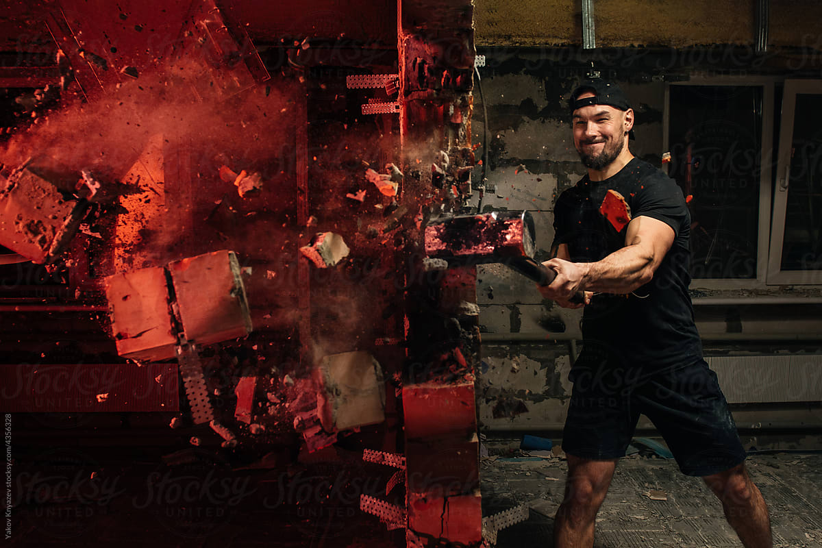 "Man Smashing Wall With Sledgehammer In Industrial Setting" by Stocksy ...