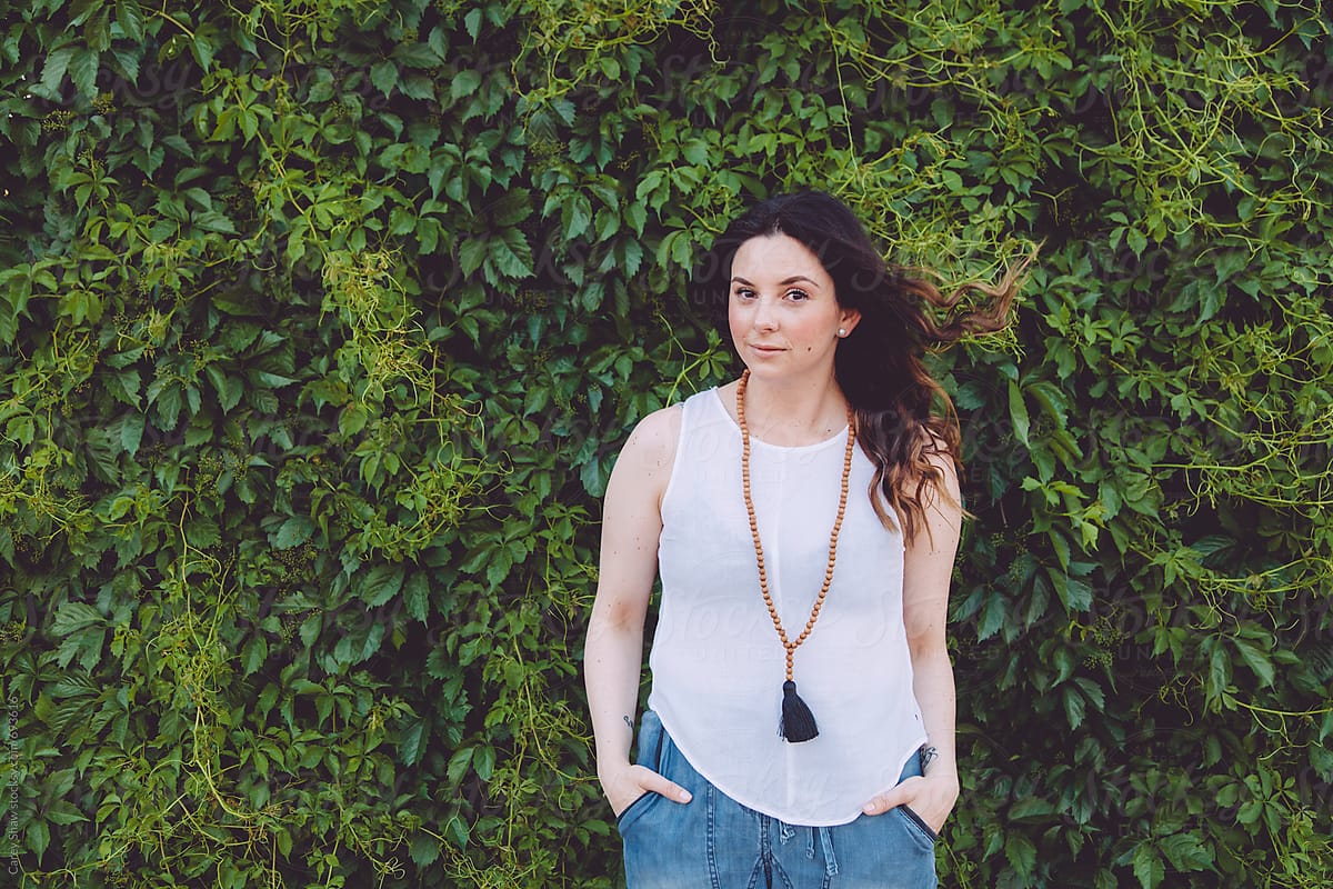 "Stylish Woman Standing Against Wall Of Greenery" by Stocksy ...
