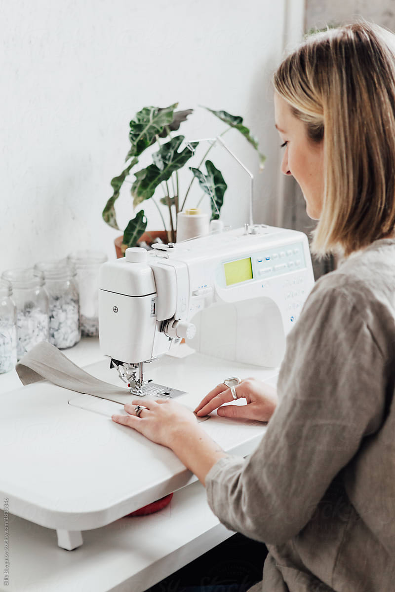 "Dressmaker Sewing At The Desk" by Stocksy Contributor "Ellie Baygulov ...