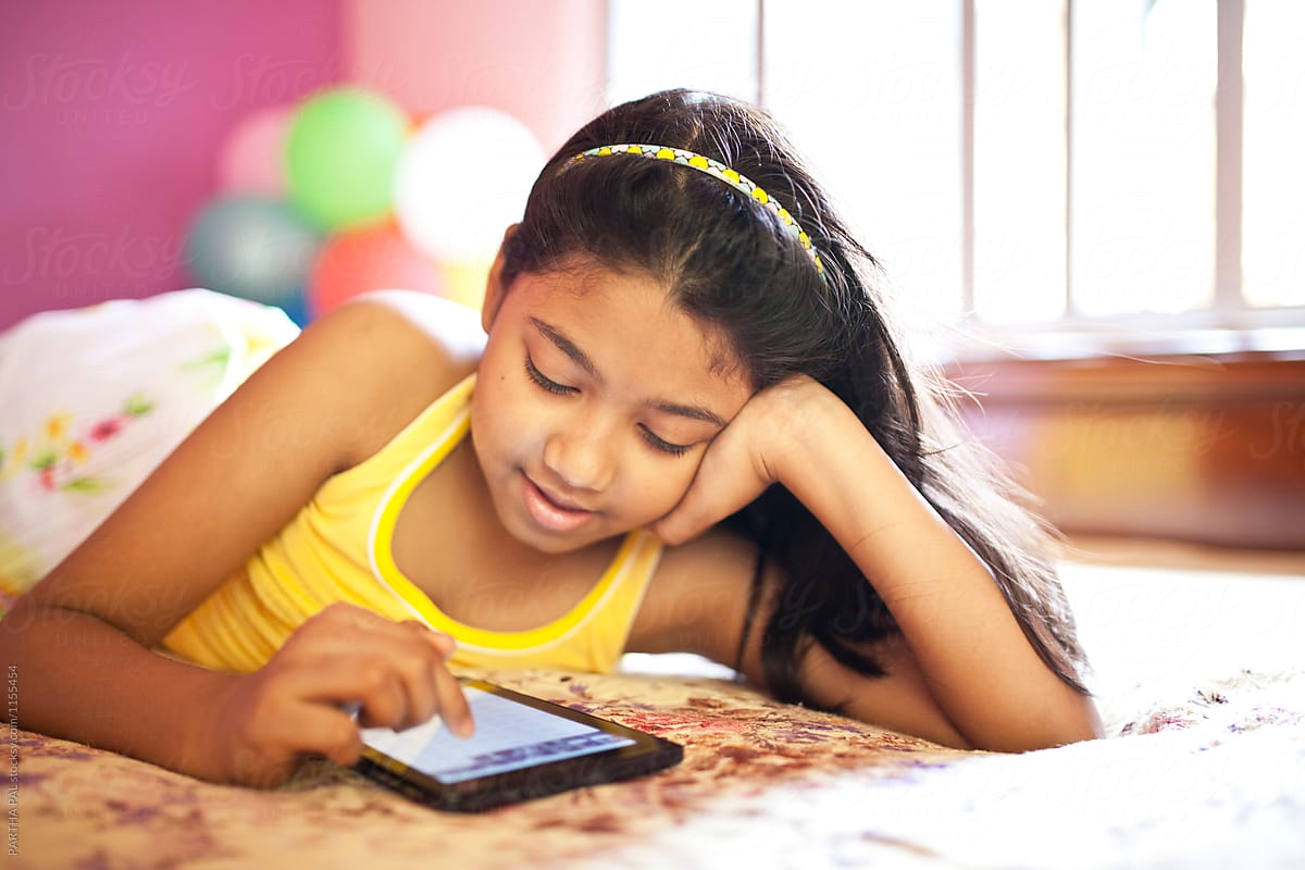 "A Little Girl Browsing With Tab Inside Room Of A Home" by Stocksy ...