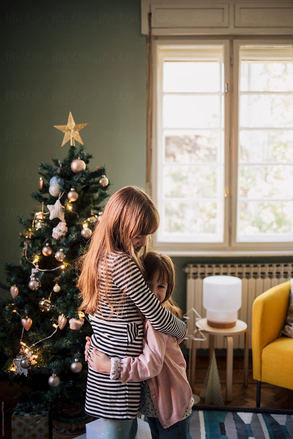 "Sisters Hugging By The Christmas Tree" by Stocksy Contributor "Lumina ...