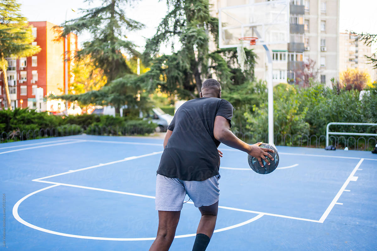 "Man Dribbling Basketball On Outdoor Court During Game." by Stocksy ...