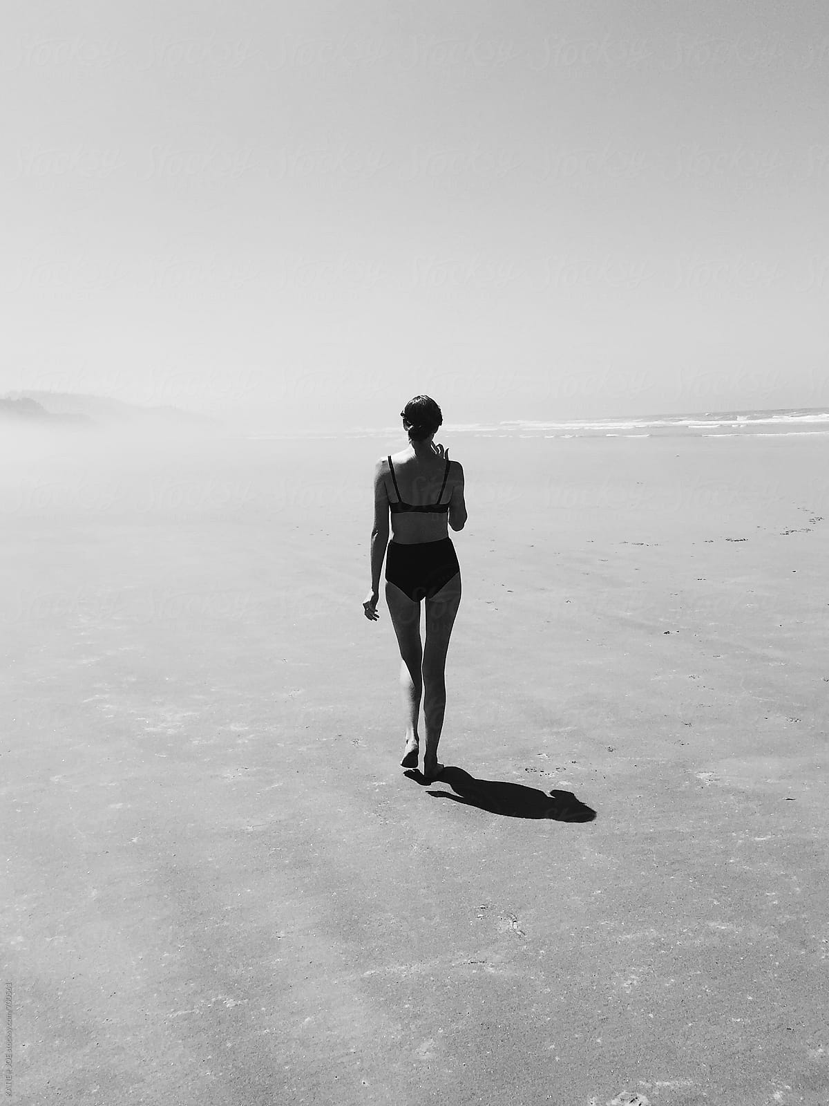  Black And White Photo Of A Girl Walking On The Beach In A Bikini By