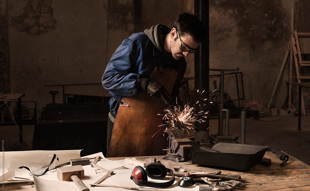"Young Man Working In His Small Workshop With Grinder Machine." by ...
