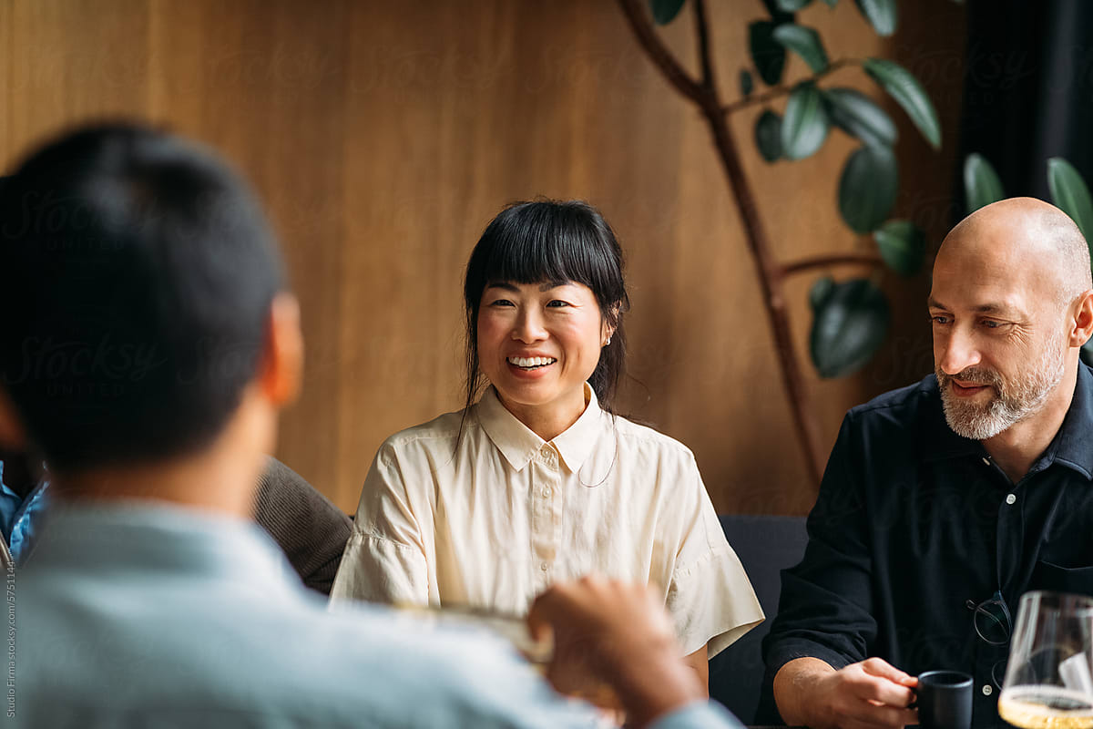 "Friends Socializing In Restaurant" by Stocksy Contributor "Studio ...