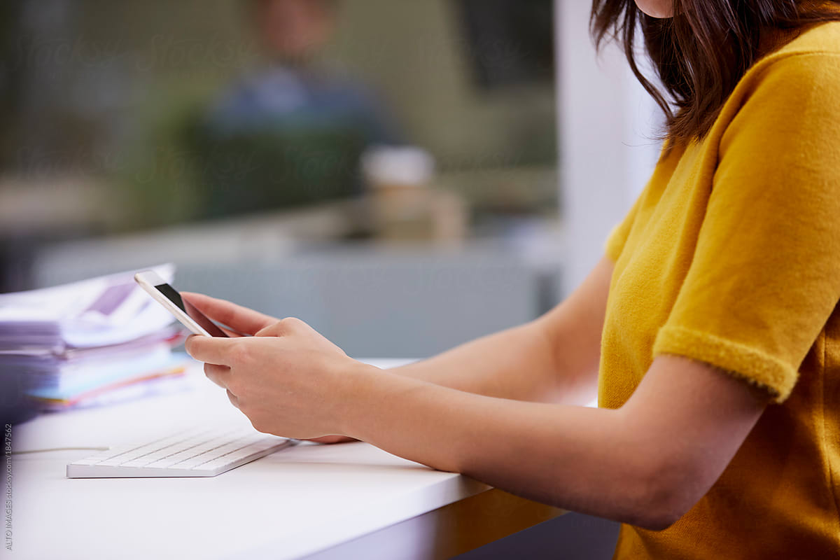 "Businesswoman Using Mobile Phone At Desk" by Stocksy Contributor "ALTO ...