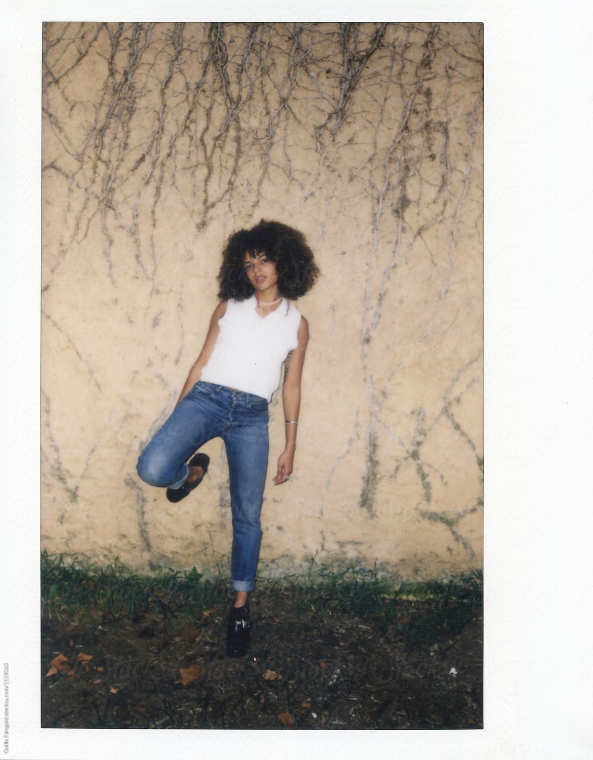 "Brunette With Afro Posing On Wall With Branches" by Stocksy ...
