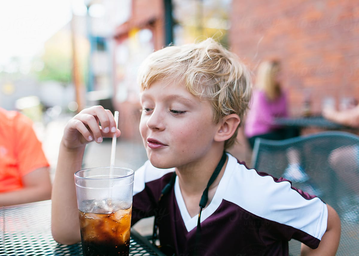 "Boy Enjoying A Soda At An Outdoor Restaurant" by Stocksy Contributor ...