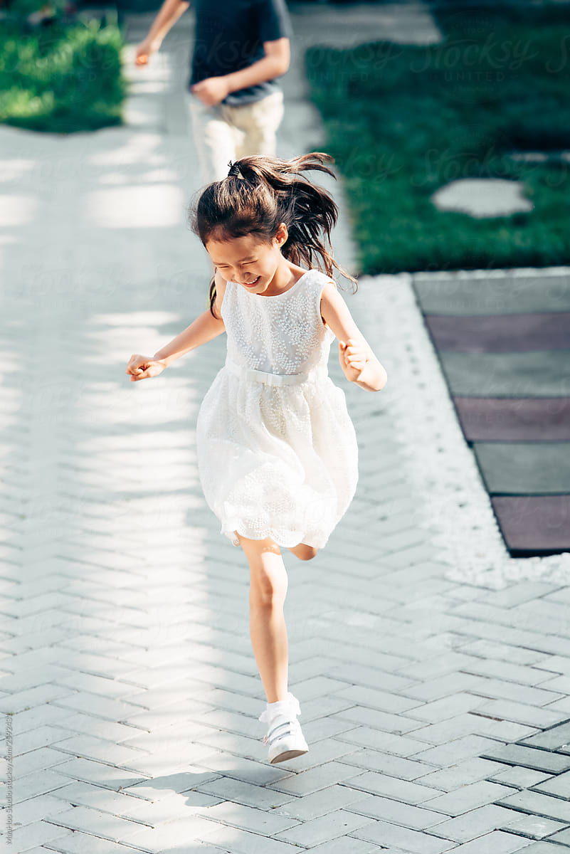 "Cute Kids Running In Yard" by Stocksy Contributor "MaaHoo" - Stocksy
