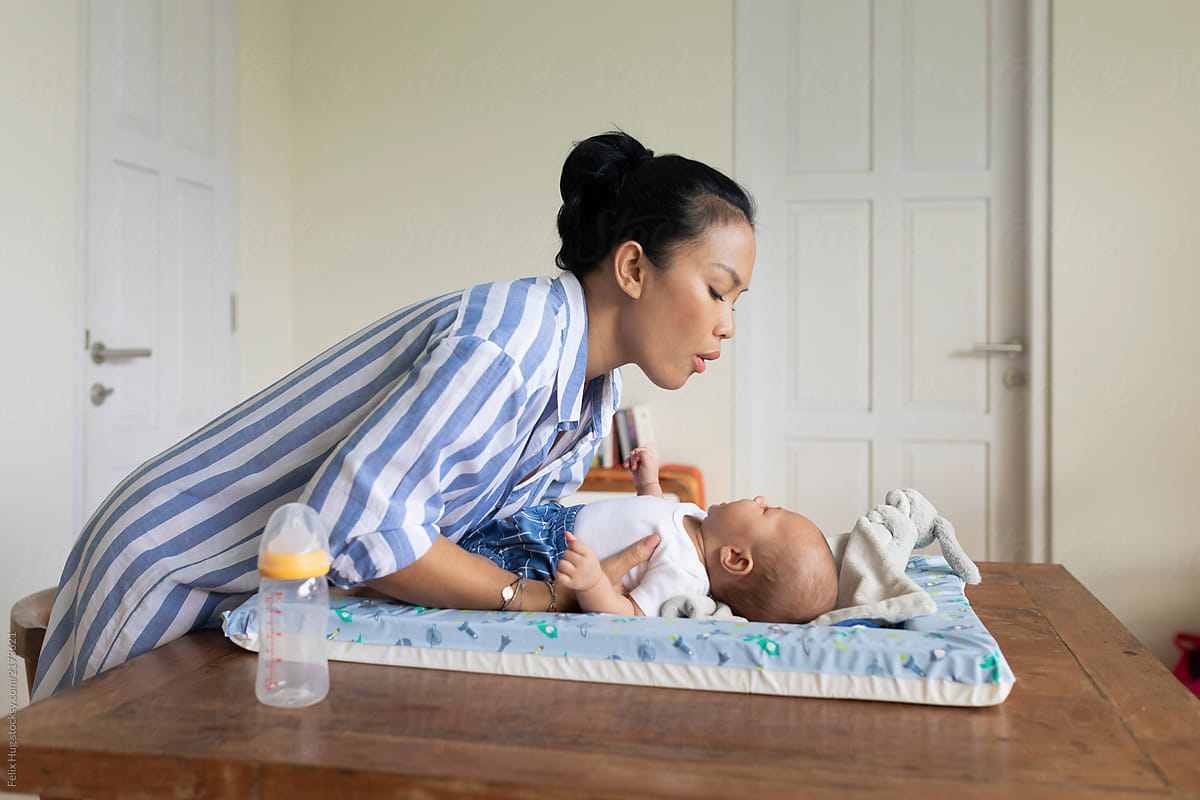 "A Beautiful Asian Mother Wearing A Striped Gown With Her Baby" by ...