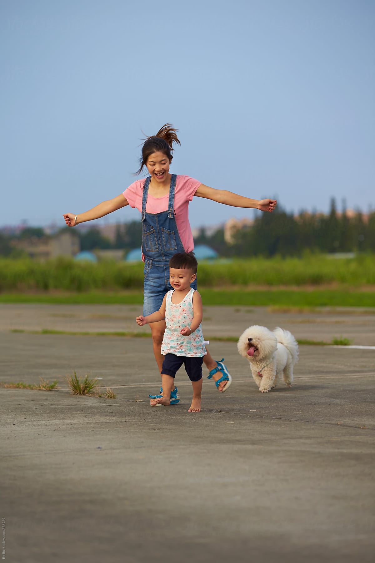 "Happy Family Outdoor With Dog" by Stocksy Contributor "Bo Bo" - Stocksy