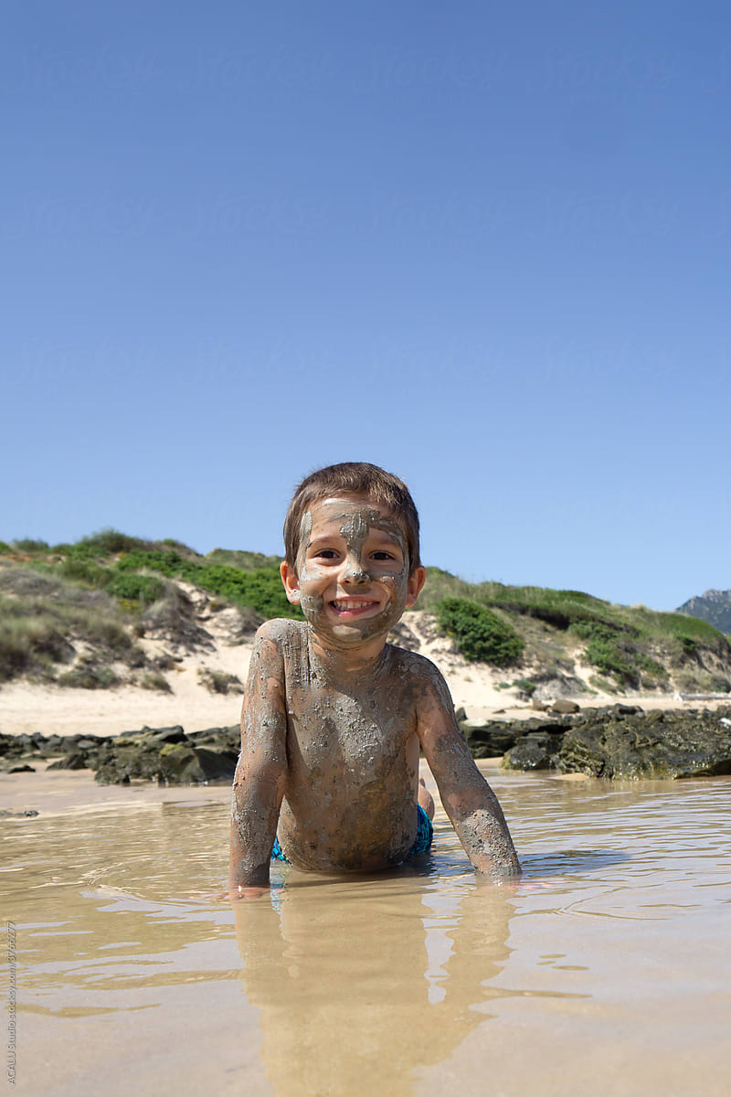"Child With The Body Slathered In Mud On A Beach" by Stocksy ...