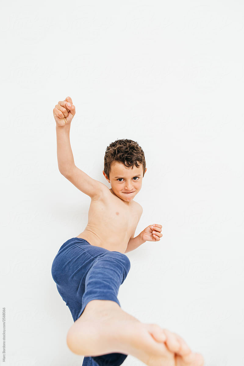 "Boy Kicking." by Stocksy Contributor "Marc Bordons" - Stocksy