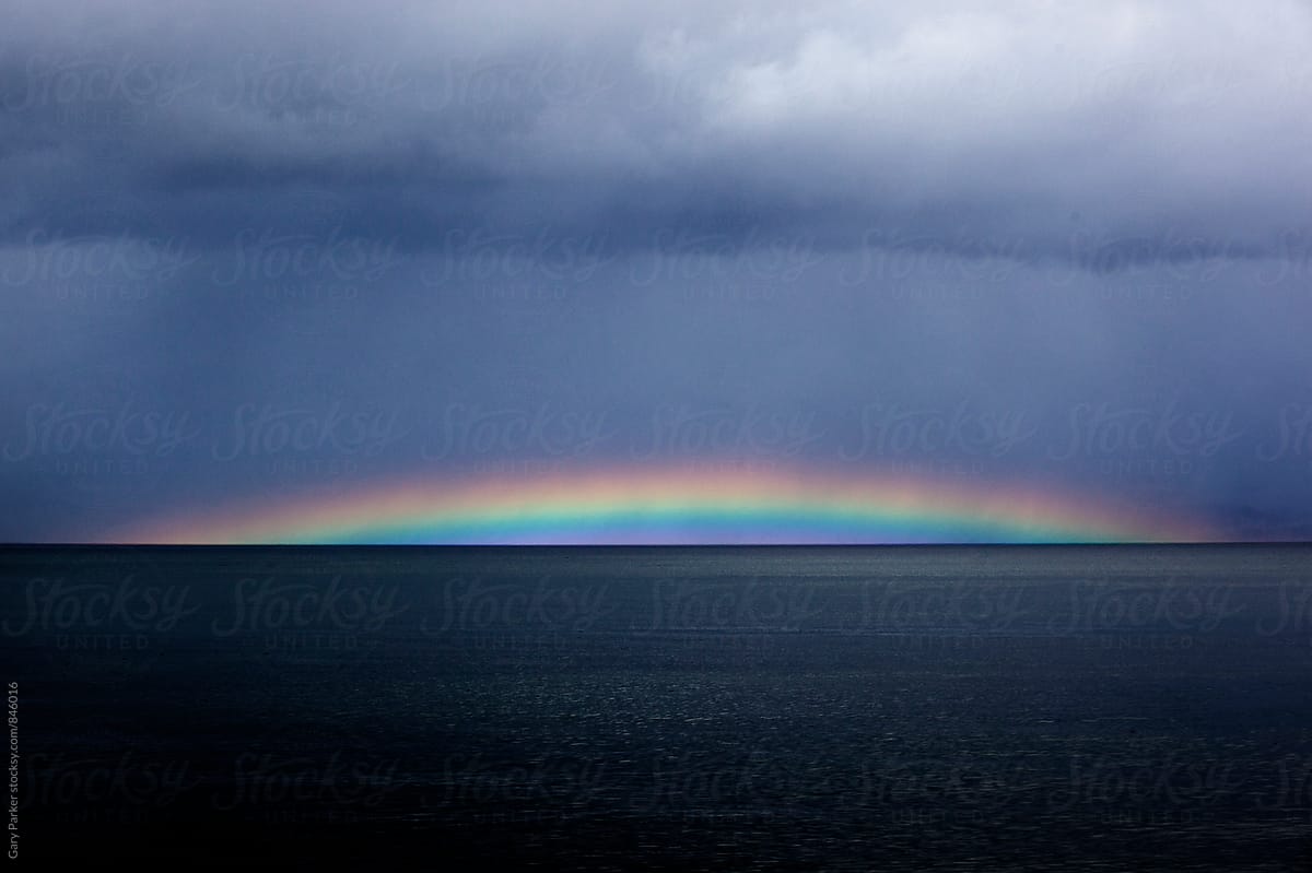 "Rainbow Over A Dark Sea" by Stocksy Contributor "Gary Parker" - Stocksy