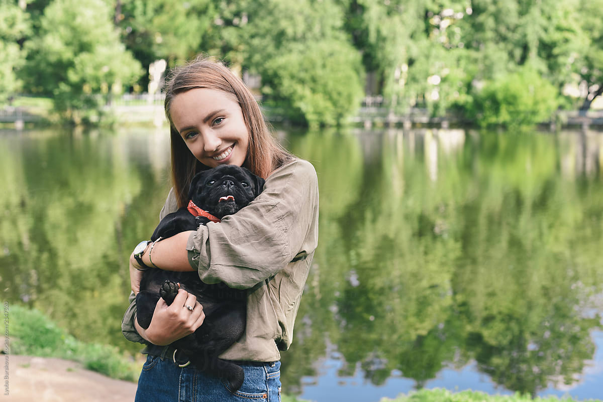 "Young Woman Holding Cute Pug On Hands" by Stocksy Contributor "Amor ...