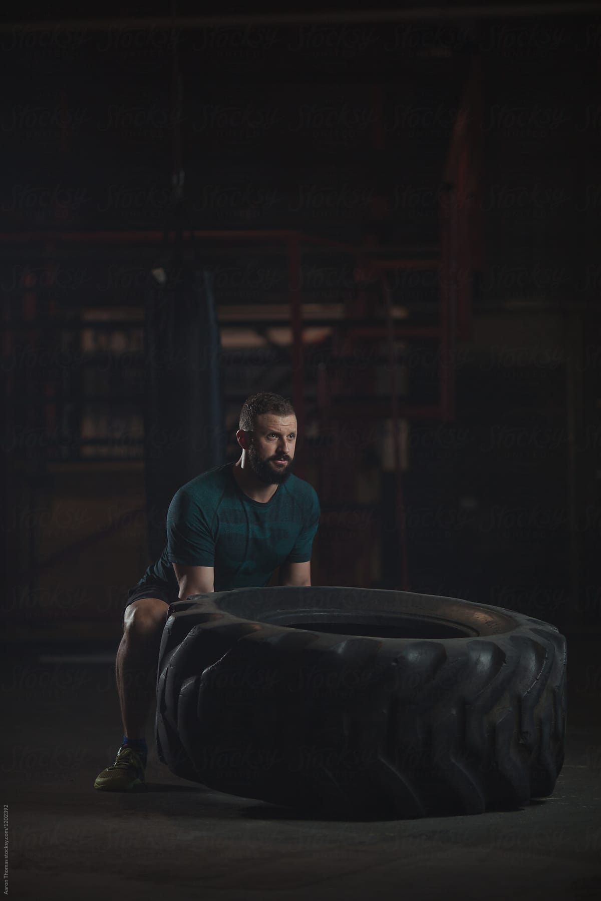 "Fit Man Lifting Tire" by Stocksy Contributor "Aaron Thomas" - Stocksy
