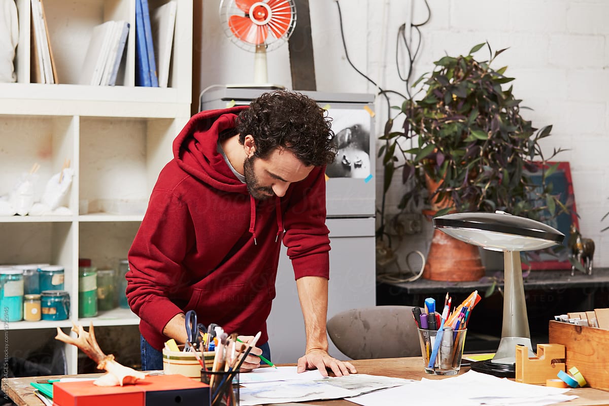 "Artist Drawing On Paper While Leaning On Table" by Stocksy Contributor ...