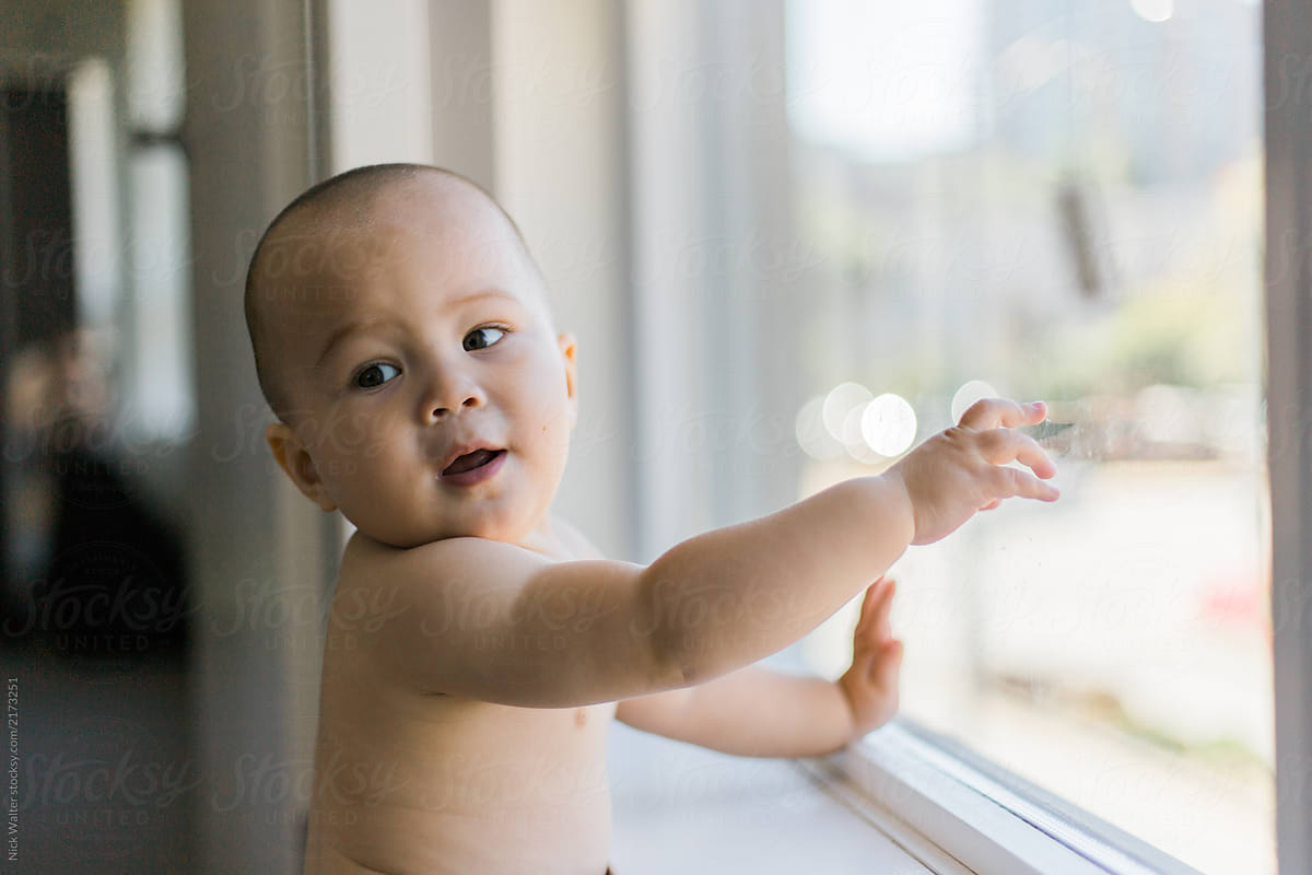"Mixed Baby Looks Out Window" by Stocksy Contributor "Nicklaus Walter ...