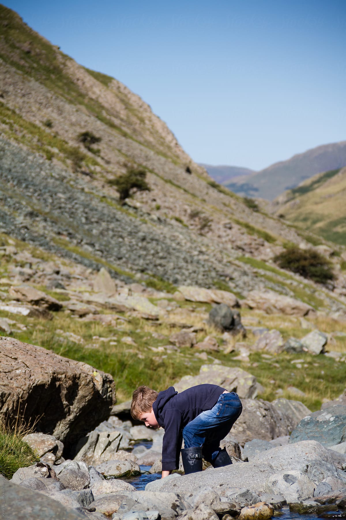 "Boy Playing In A Stream In A Valley" by Stocksy Contributor "Kirsty ...