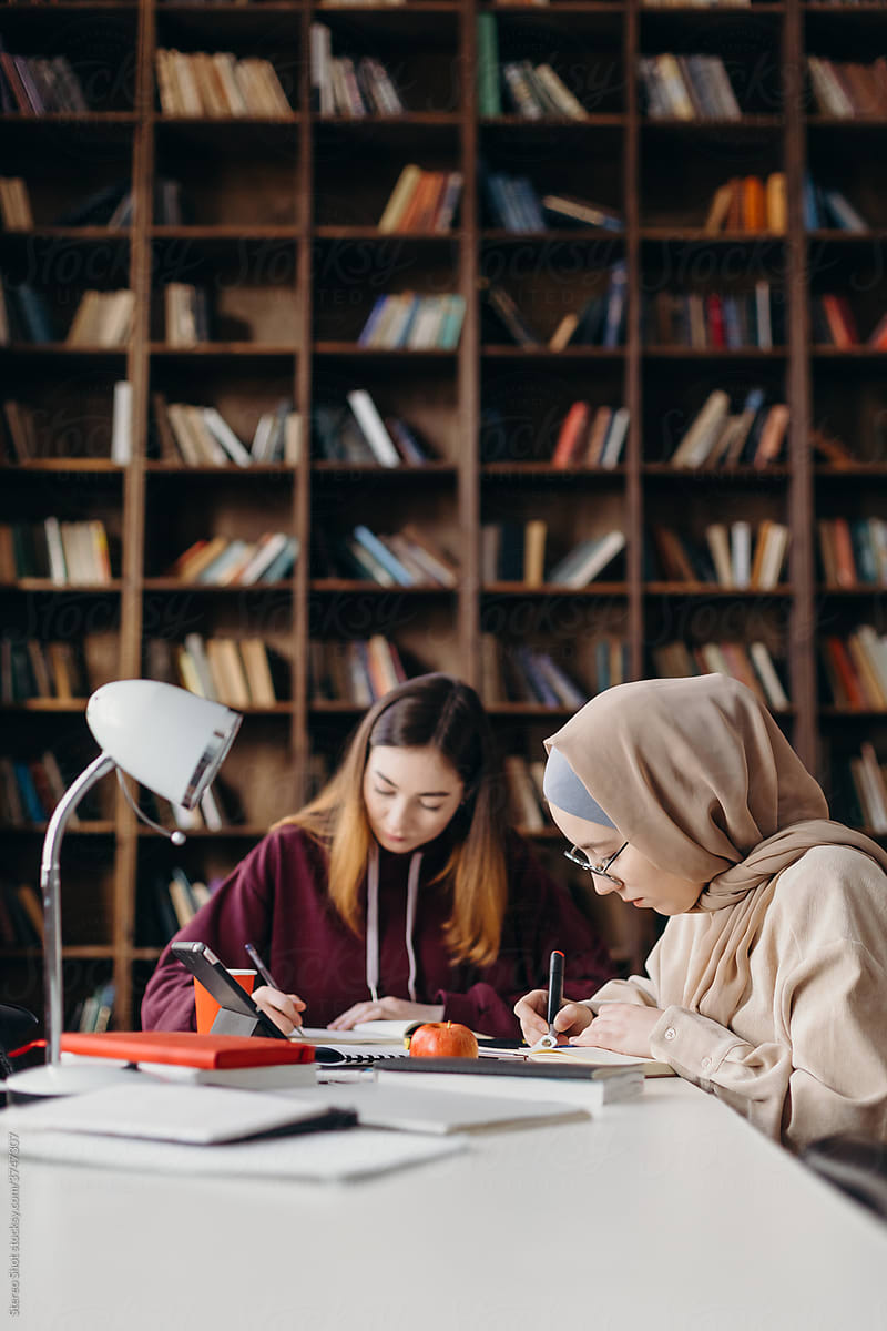 "Serious Female College Students Working On Project In Library" by ...