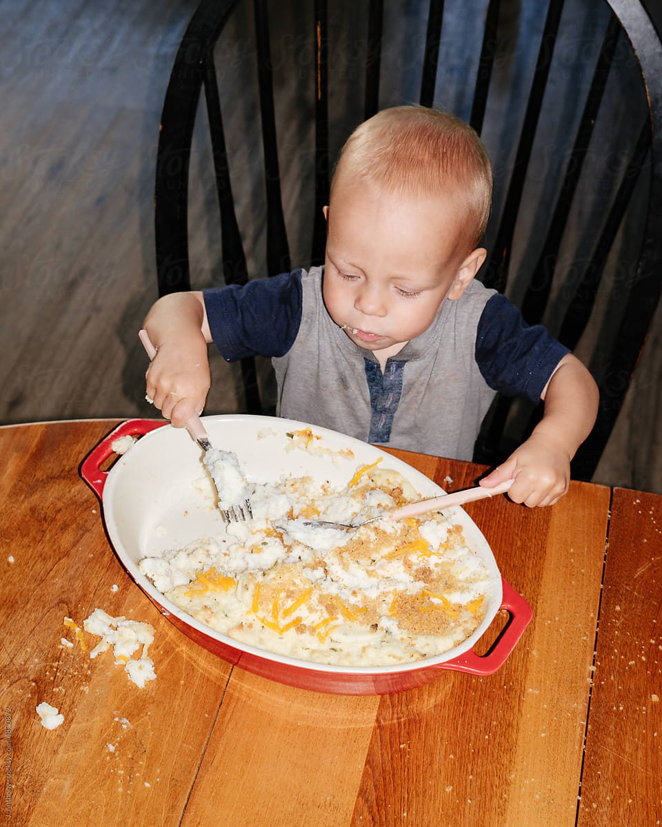"Kid Eating Mashed Potatoes" by Stocksy Contributor "J. Anthony" - Stocksy