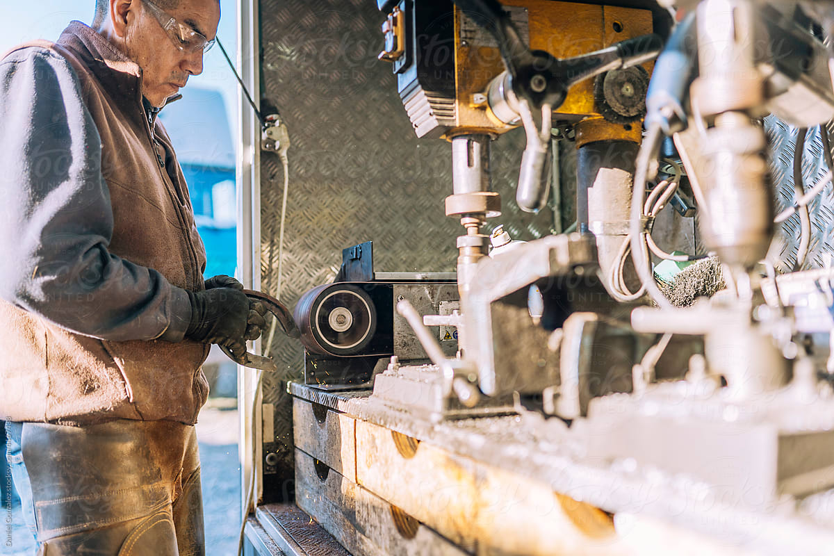 "Man Grinding Horseshoe On Machine At Workbench" by Stocksy Contributor ...