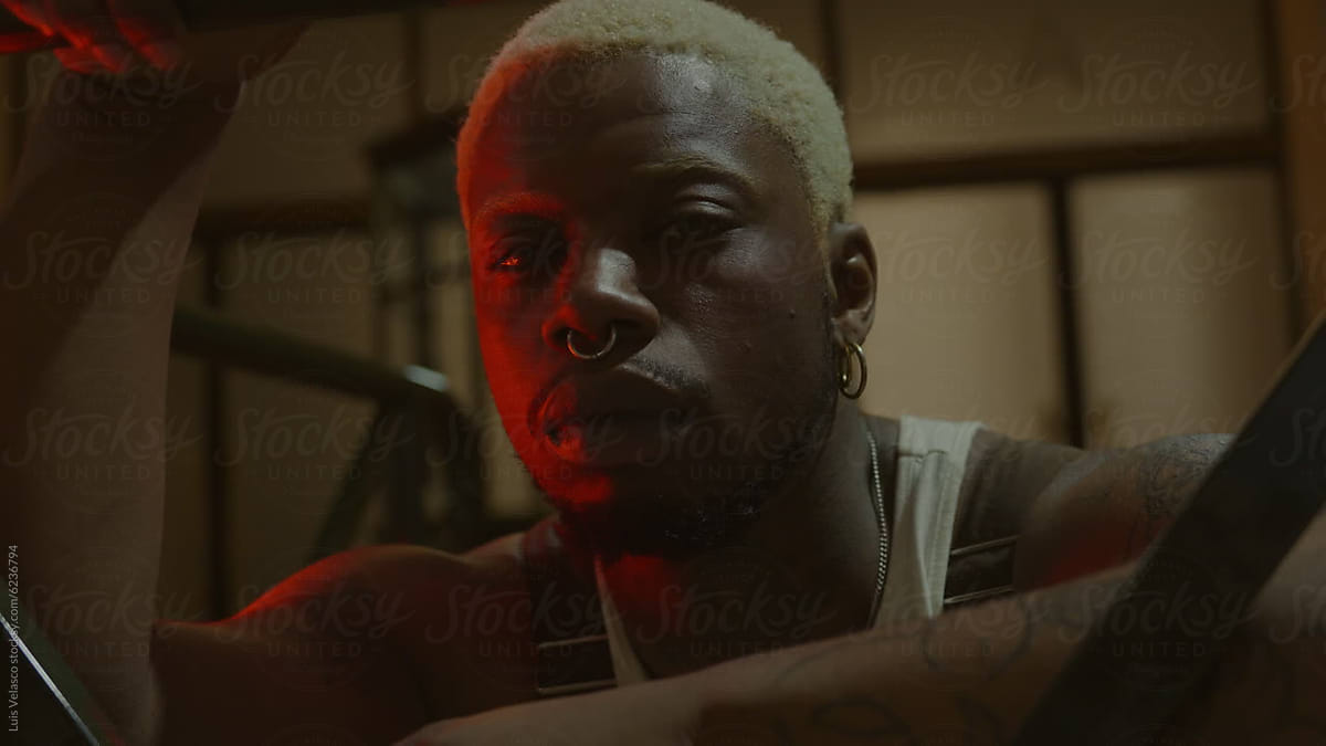 "Alternative Black Man With Blond Hair Leaning On Railings At Night" by ...
